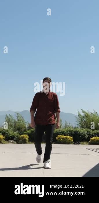 Young man walking across the bridge, front view of young man crossing ...
