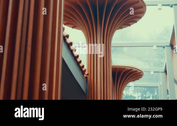A modern architectural interior featuring unique wooden columns with a ...