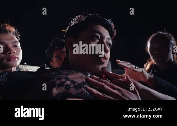 A group of young men with serious expressions, illuminated by dramatic ...