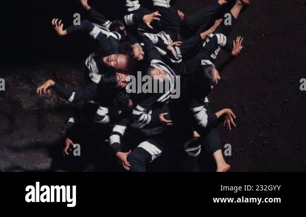 A dramatic scene featuring a young man in a black outfit standing ...