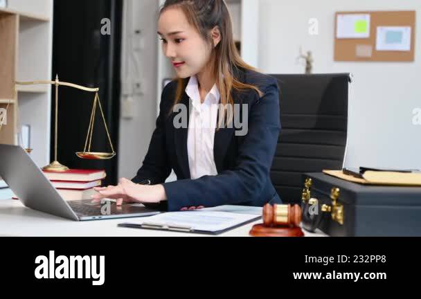 Professional female lawyer working on laptop computer at a desk ...