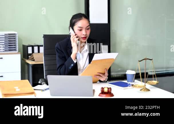 Professional female lawyer working with documents and talking on ...