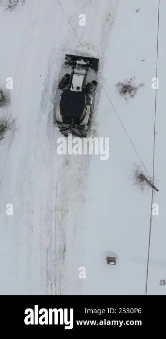 Aerial drone view of the snow plow machine, opening the roads on the ...