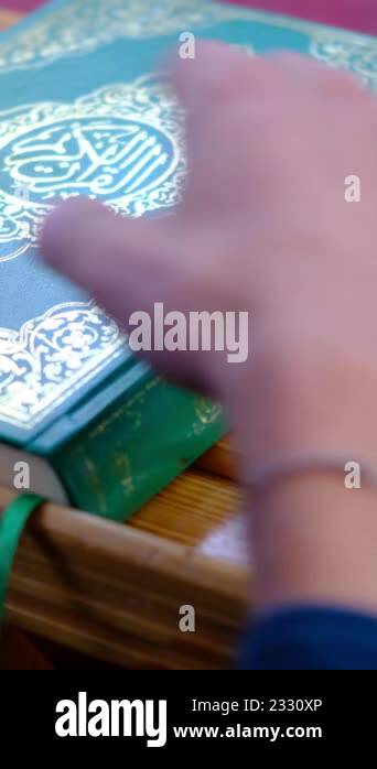 Close-up view of opening the cover of the quran standing on the table ...