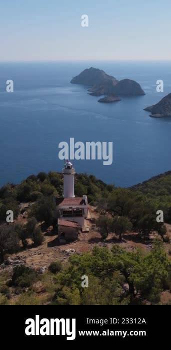 Unique view of the lighthouse on the edge of the cliff, sea and island ...