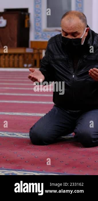 An old man masked raising his hands and praying from the mosque, Muslim ...