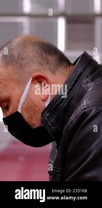 Close-up side view of a man with a black mask on his face finishing ...