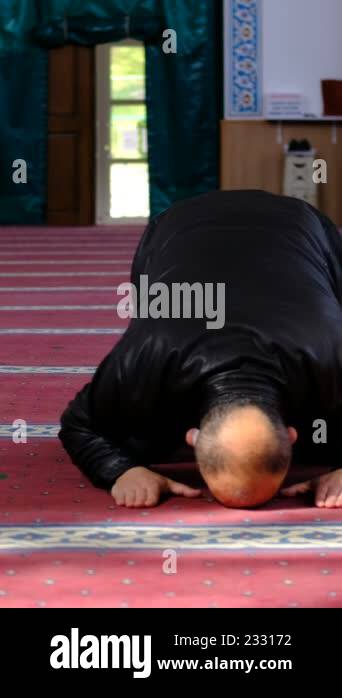 Front shot of a mature man with a black mask on face praying in the ...