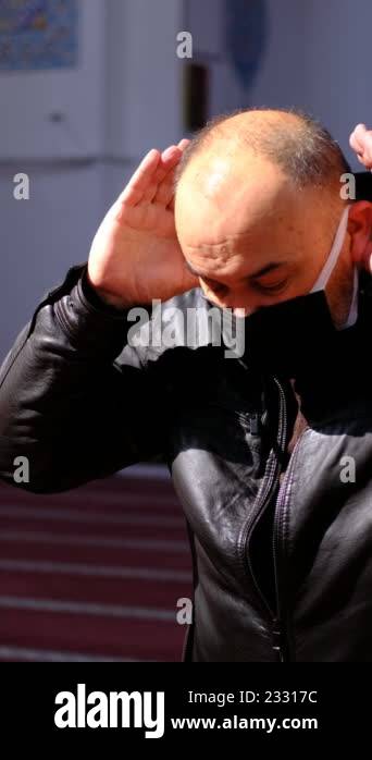 Close-up view of bald man with face mask praying, Muslim men who begin ...