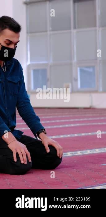 Young man with a health mask on his face praying sitting in the masjid ...