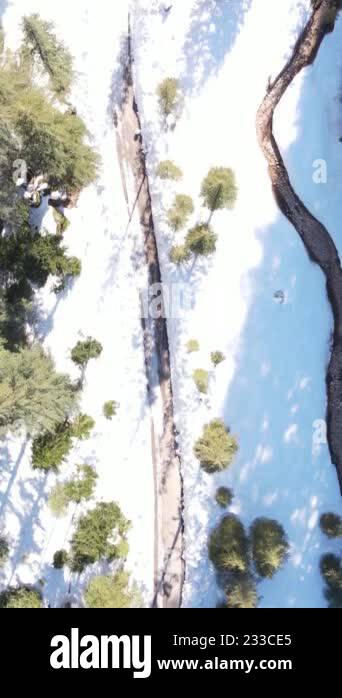 River with snowy banks flowing through a crevice in winter forest with ...