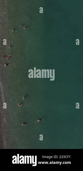 Drone footage flying over people spending time at sea during summer ...