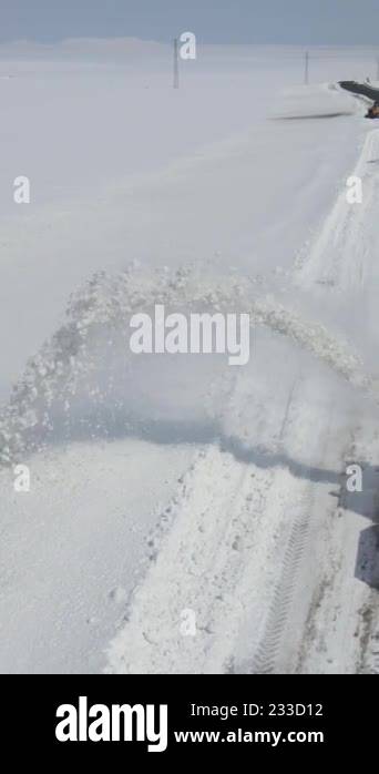 aerial view of snow plower working in winter conditions, drone shot ...