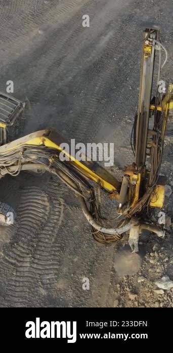 Aerial drone view of the earthwork site of excavator, a pile of earth dug with construction ...