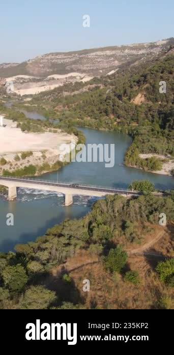 Aerial drone view of vehicles moving on a magnificent river flowing in ...