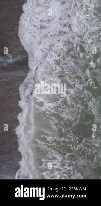 Drone view of sparkling waves mixing with beach sand, aerial wave view ...