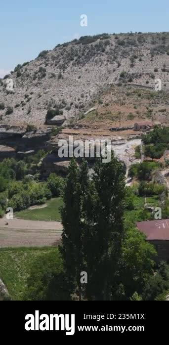 An old village in the greenery and sparse trees on the hills of a ...
