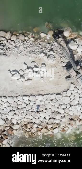 The construction machine, which does landscape work on the shore, is ...