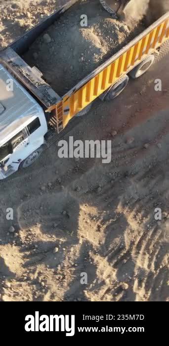 aerial view of construction site machine digger loading soil on truck ...