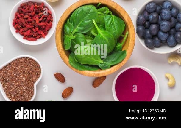 Various superfoods on white marble background. Vegetables, matcha, acai ...