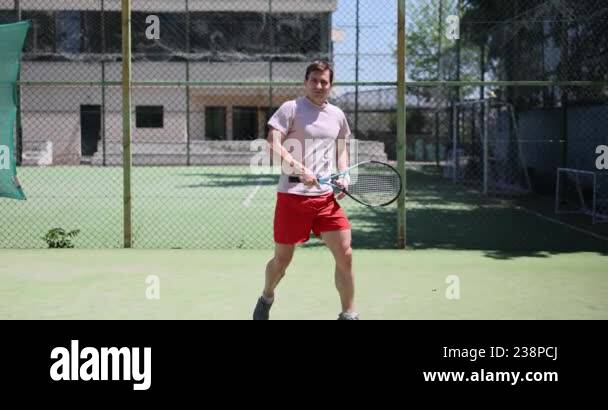 Man practices tennis skills on the court and feels unwell. Sports ...