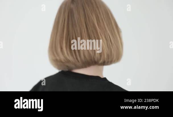 Young woman student turns her back and walks away on white background ...