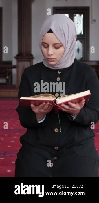 Young muslim woman reading the quran inside the mosque, reciting al ...
