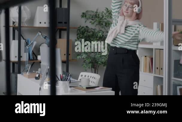 Slow motion of joyful young woman listening to music with headphones ...