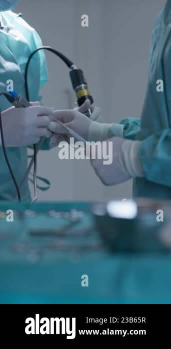 Vertical Screen: Close-up of surgeons performing a minimally invasive ...