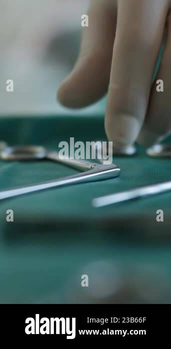 Vertical Screen: Close-up of surgical instruments on a sterile table in ...