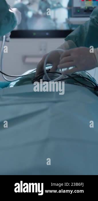 Vertical Screen: Surgeons in sterile gowns preparing endoscopic ...