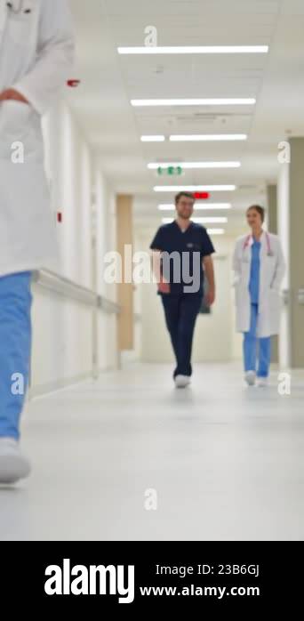 Vertical Screen: Healthcare professionals walking and conversing in a ...