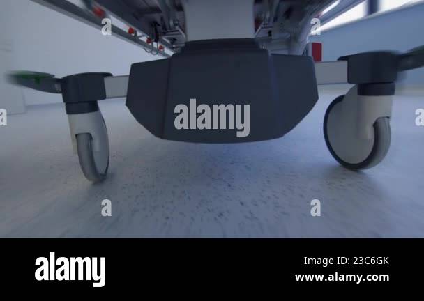 Close-up view of medical bed wheels moving on a hospital floor ...