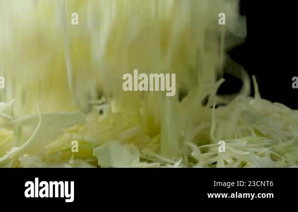 Slow motion of falling shredded white cabbage on a black background ...
