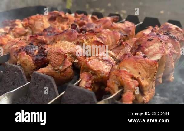 Meat cooked on skewers on a mangal. Delicious grilled food. Pork cooked ...