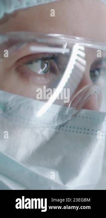 Vertical close up shot of healthcare worker wearing protective goggles ...