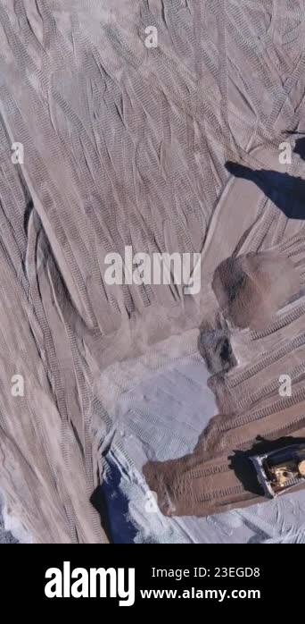 Aerial view construction workers operate heavy machinery to shape land ...