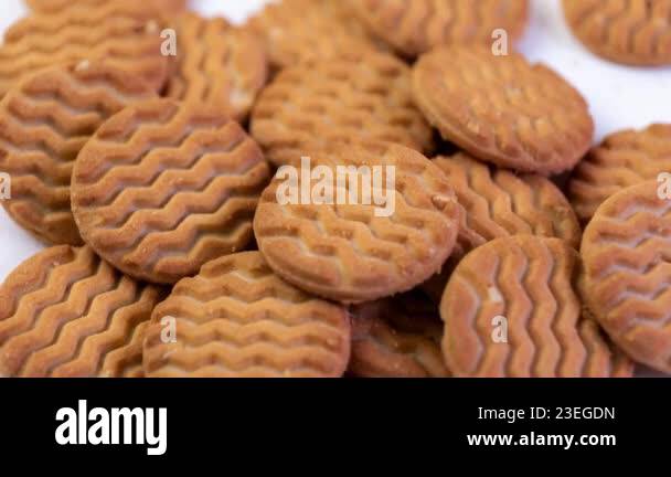 Close-up shot of many round, textured cookies. They are light brown and ...