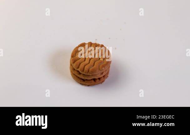 Close-up shot of several round, brown cookies stacked neatly. The ...