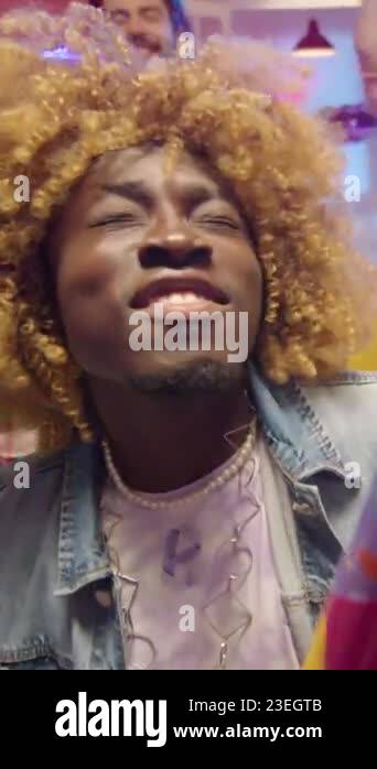 Vertical UGC shot of happy African American gen Z guy popping party ...