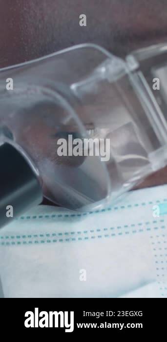 Vertical close-up shot of Black male researcher with safety glasses and ...