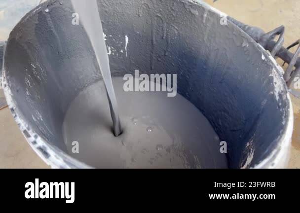 Slow mix quartz material is being prepared in a bucket, demonstrating ...