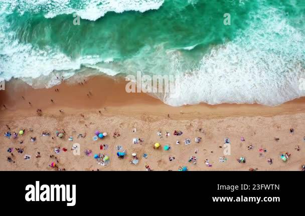 Aerial perspective captures a bustling beach where families and friends ...