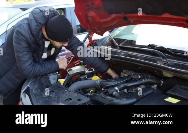 Mans Hands Using Tools to Repair a Car Engine Beneath the Open Hood ...