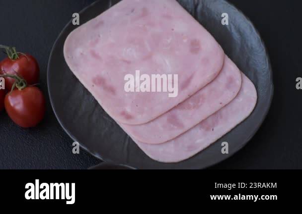 Boiled ham with salt and spices cut into slices on dark concrete ...