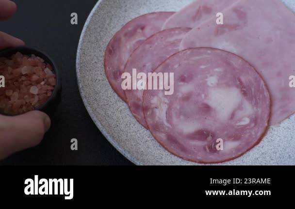Boiled ham with salt and spices cut into slices on dark concrete ...