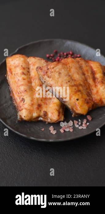 Grilled fish fillet with salt, spices and herbs on dark concrete ...