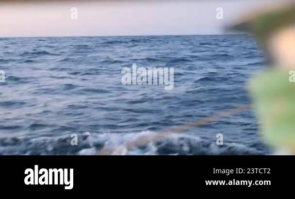 Ocean seen across an out of focus winch on a sailboat crossing the Bay ...