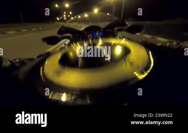 Male motorcyclist riding on modern sport bike in illuminated city empty ...