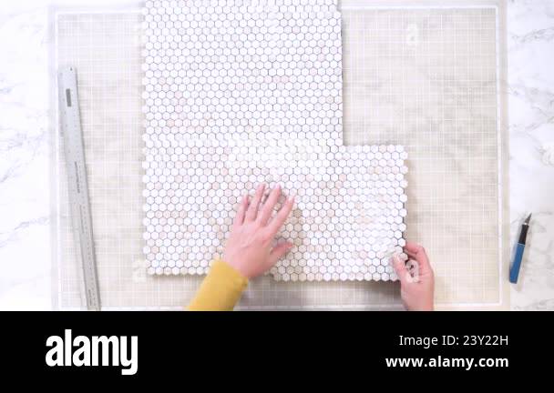 Flat lay. In the process of mounting peel and stick mosaic tiles onto a ...